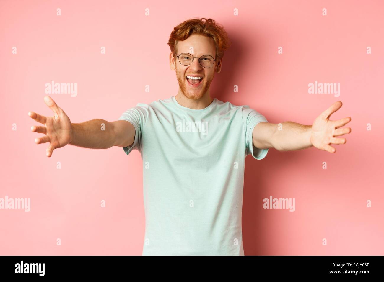 Young friendly man with red hair and beard reaching hands for hug ...