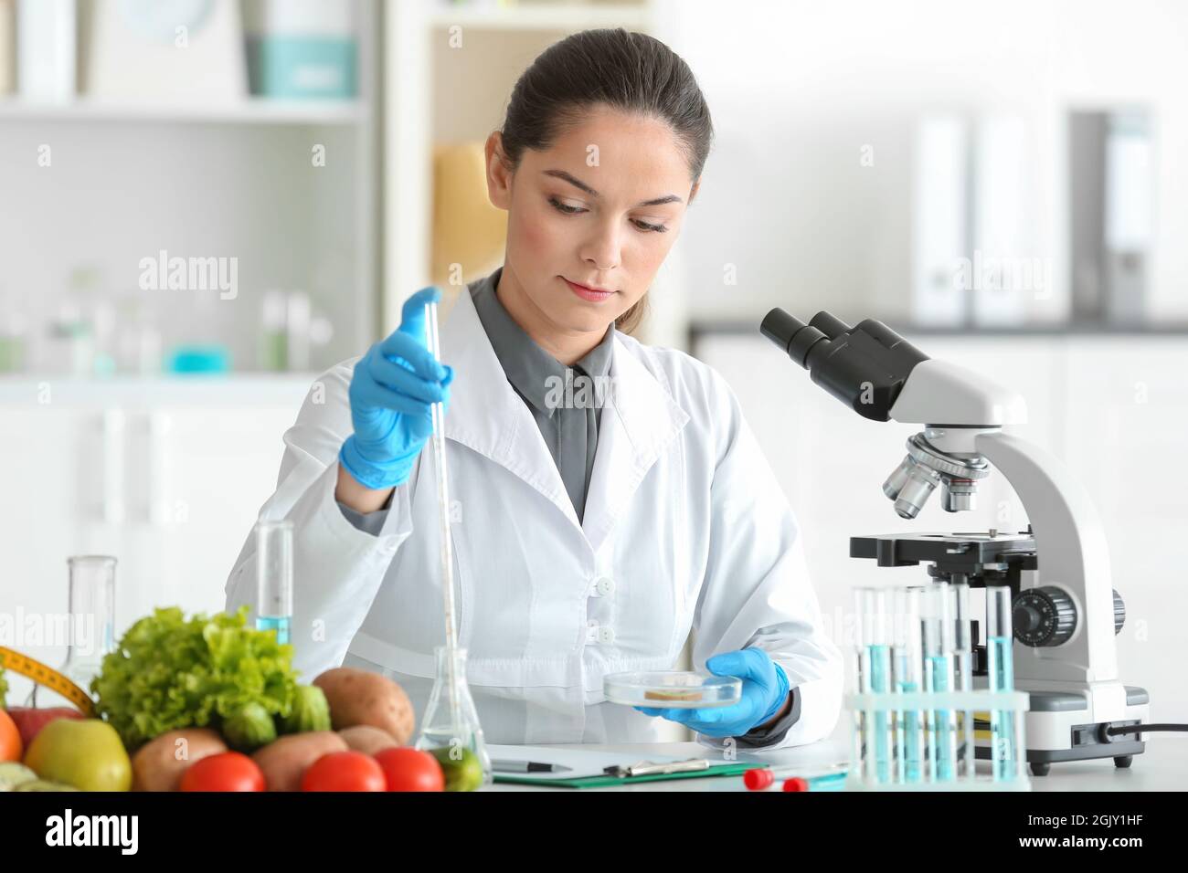 Young female nutritionist testing food samples in laboratory Stock ...