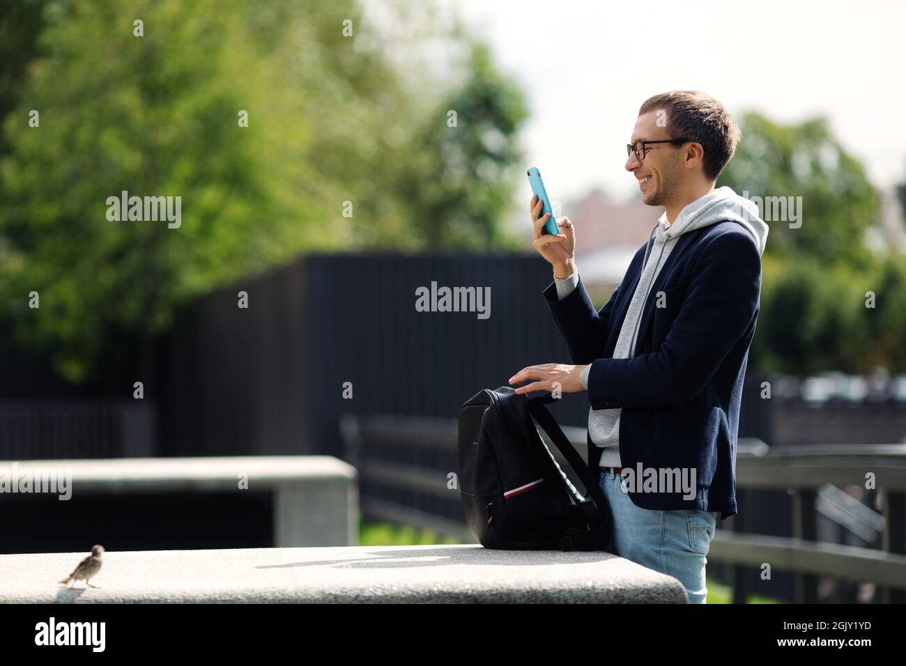 Excited casual man with backpack for laptop read text message in ...