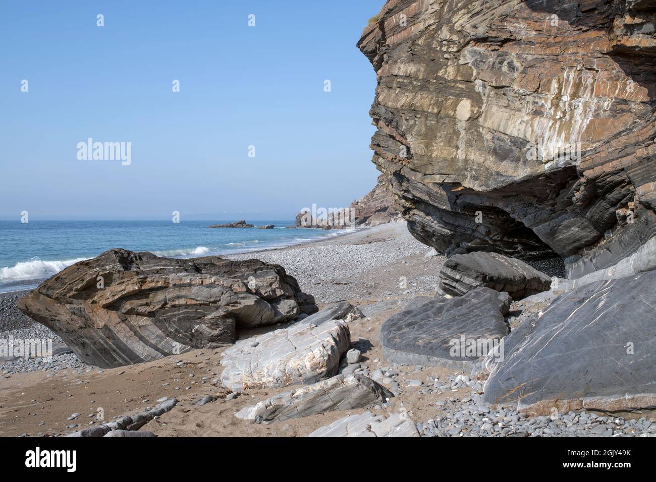 Millook Beach is a large pebble beach backed by impressive cliffs Stock ...