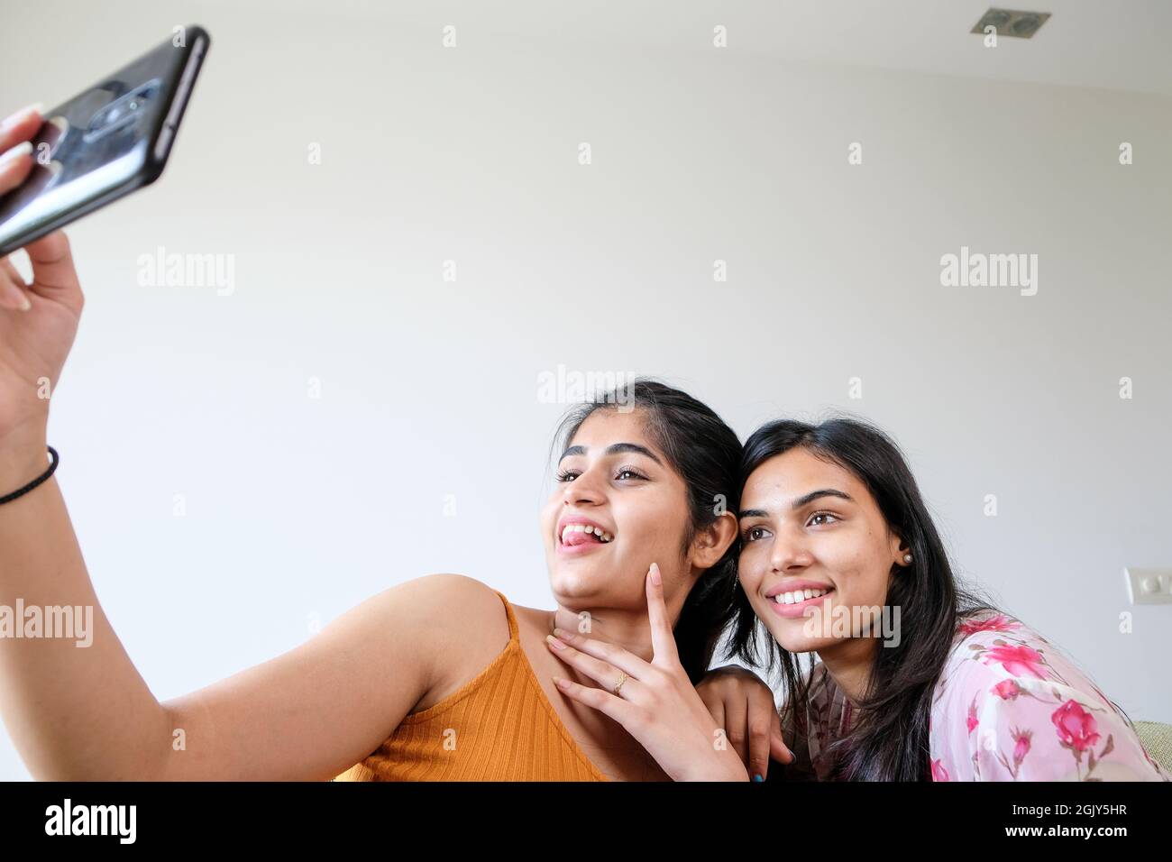 Two Indian best friends happily taking a selfie at home Stock Photo - Alamy