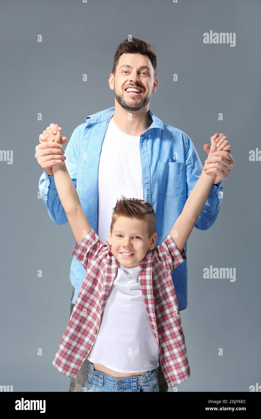 Father and son having fun on color background Stock Photo - Alamy