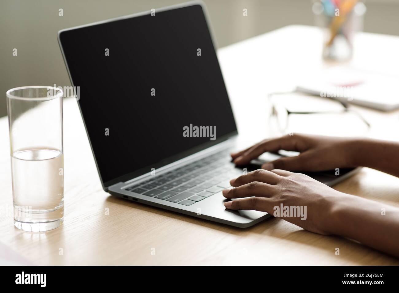 Teenage afro american girl pupil typing on laptop with empty screen ...