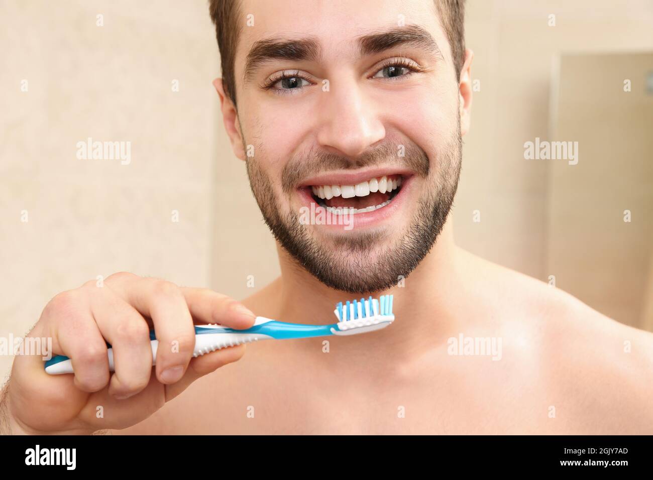 Handsome man brushing teeth in bathroom Stock Photo - Alamy