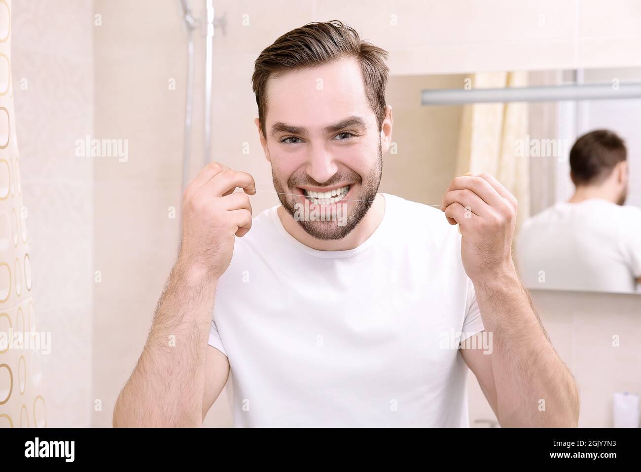 Handsome man brushing teeth in bathroom Stock Photo - Alamy