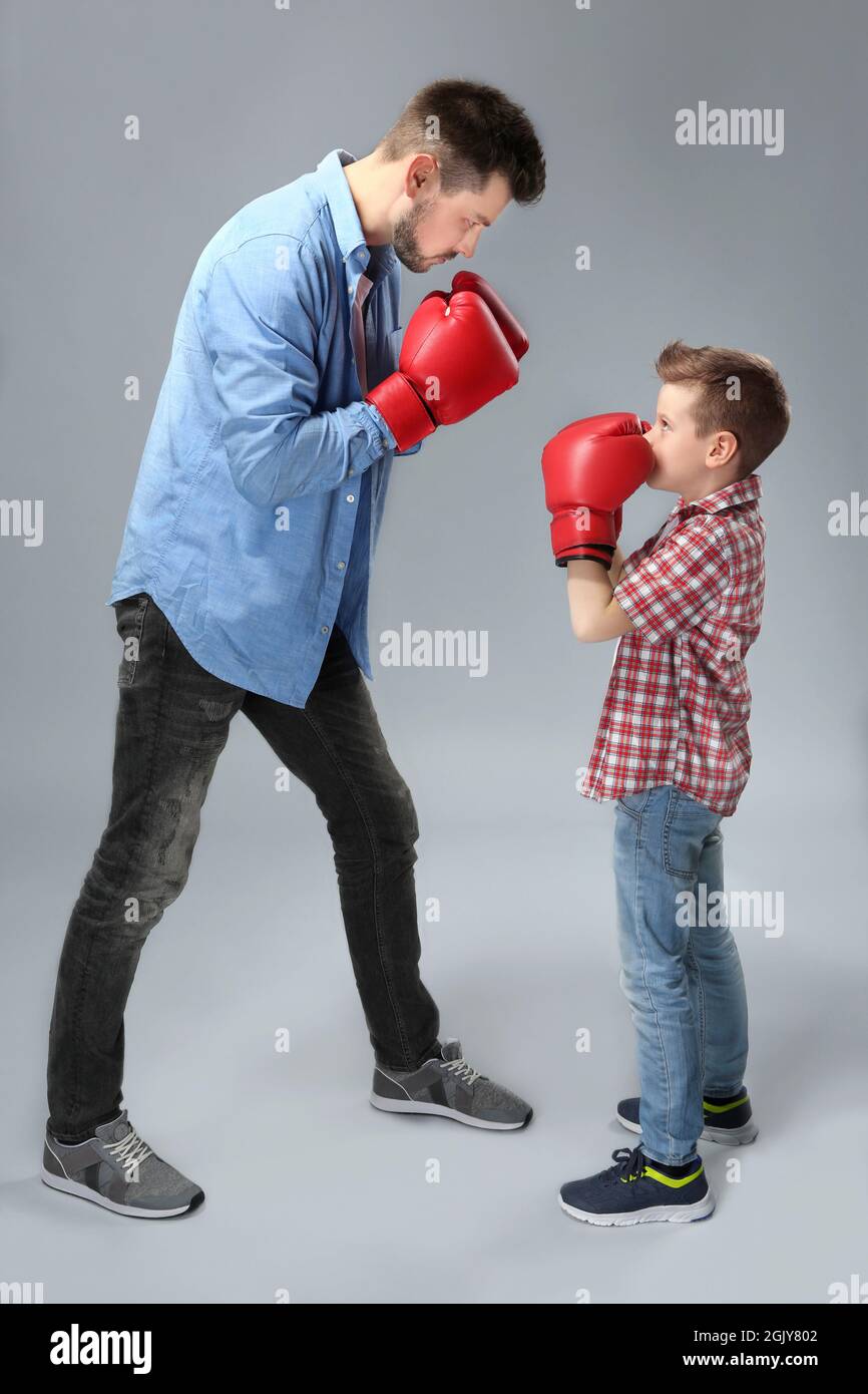 Father and son having boxing training on color background Stock Photo ...