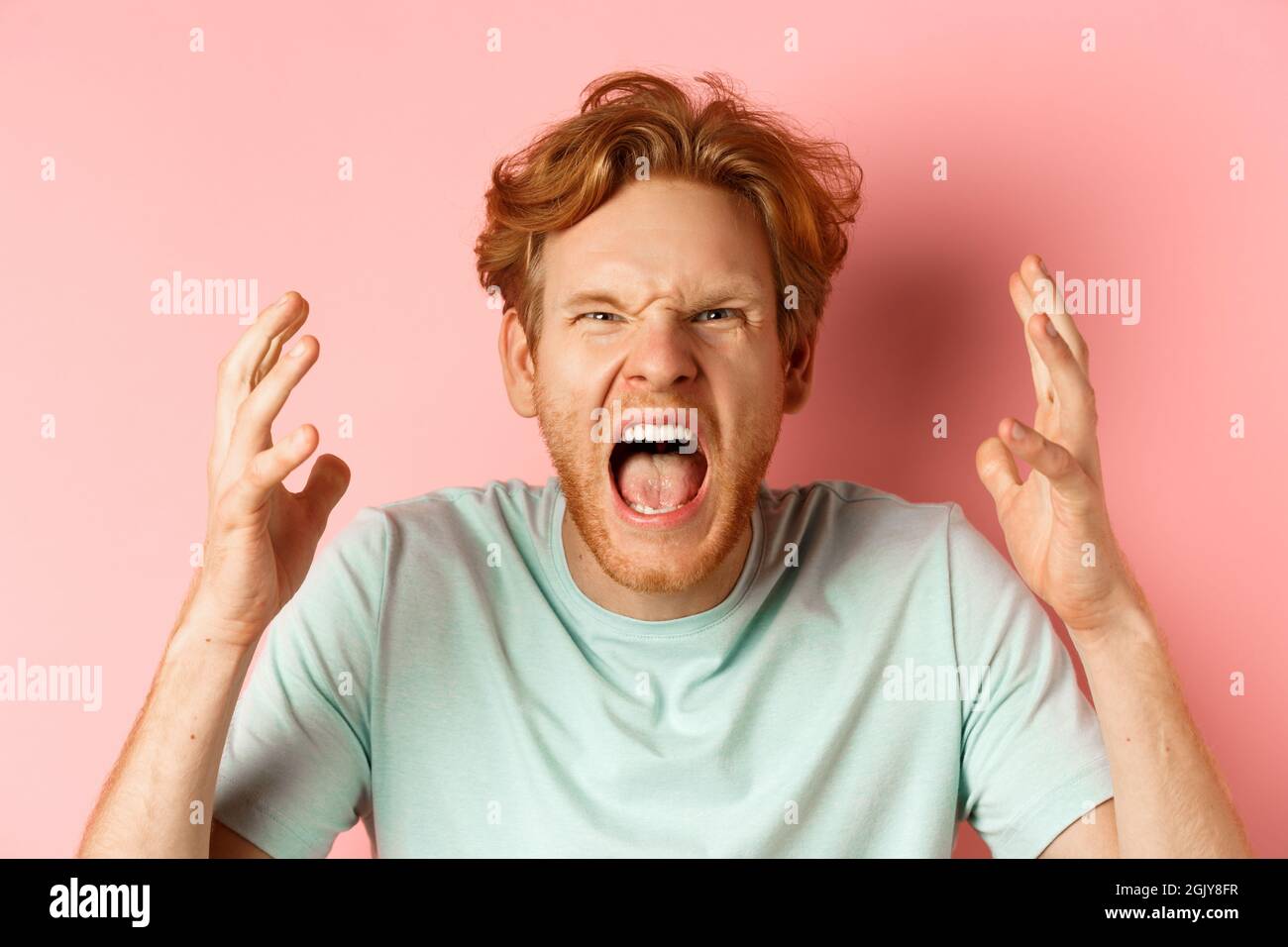 Face of angry redhead man shouting and shaking hands furious, staring ...