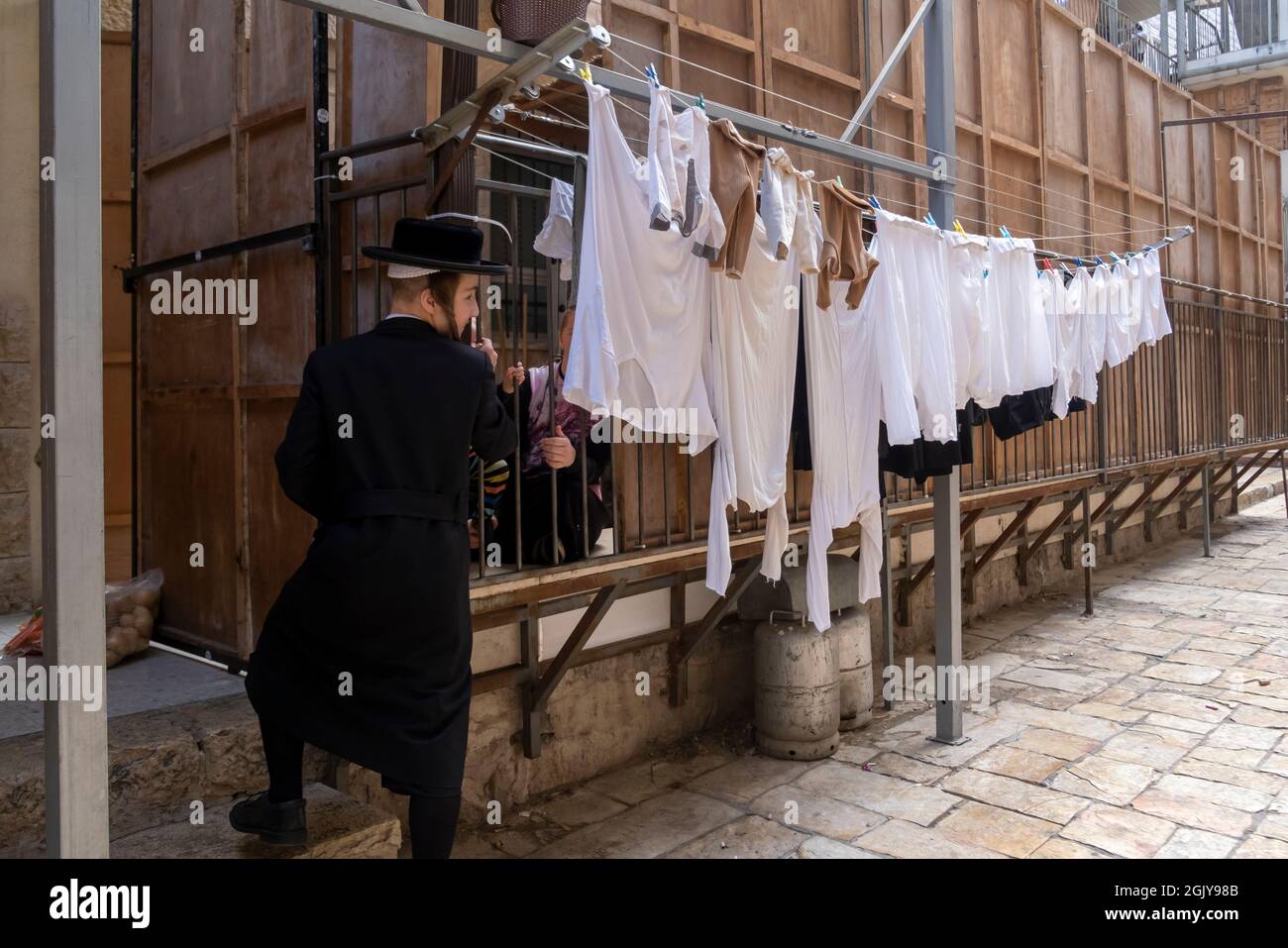An Orthodox Jew stands by a wooden sukkah temporary hut constructed for ...