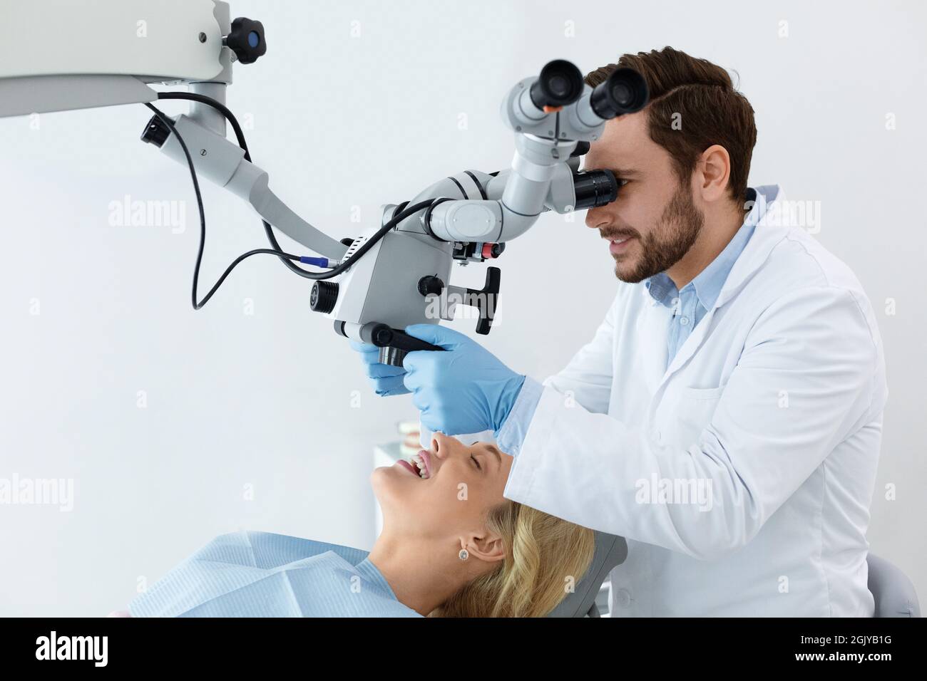 Stomatologist looking at dental microscope, using innovative tools ...