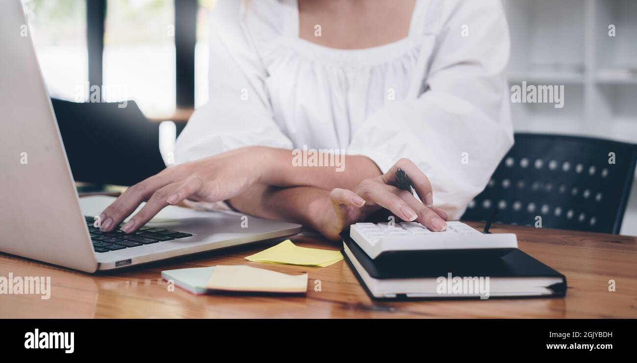 Business woman or accountant is using a calculator to calculate ...