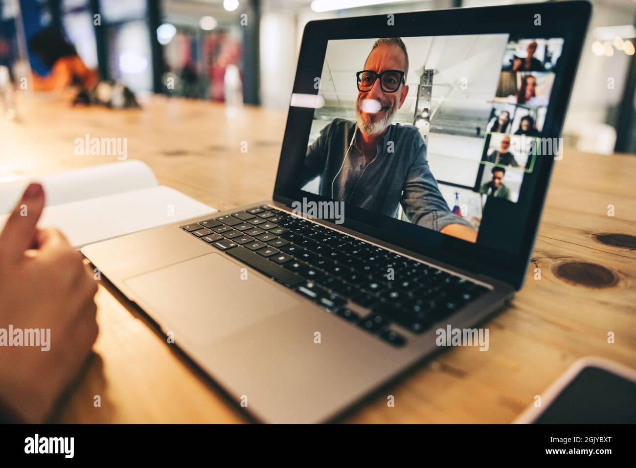 Anonymous businesswoman attending a virtual meeting in a modern office ...