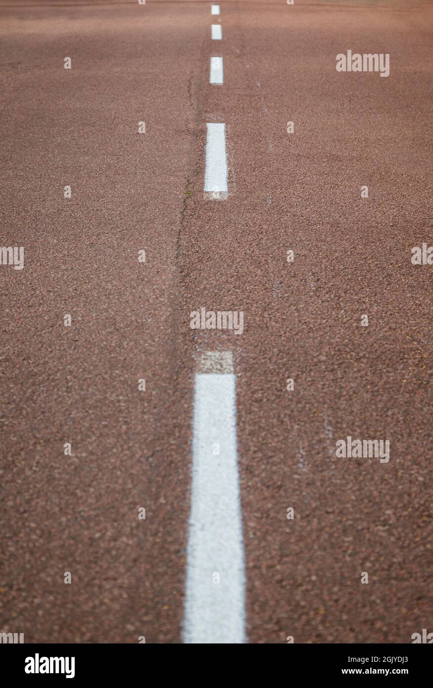 Reddish asphalt road with white dashed line. High resolution full frame ...