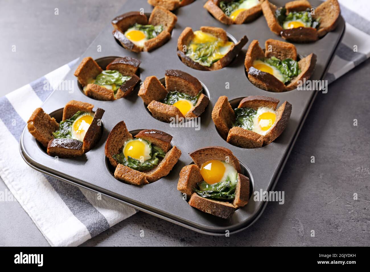 Baking mold with eggs and spinach on gray table Stock Photo - Alamy