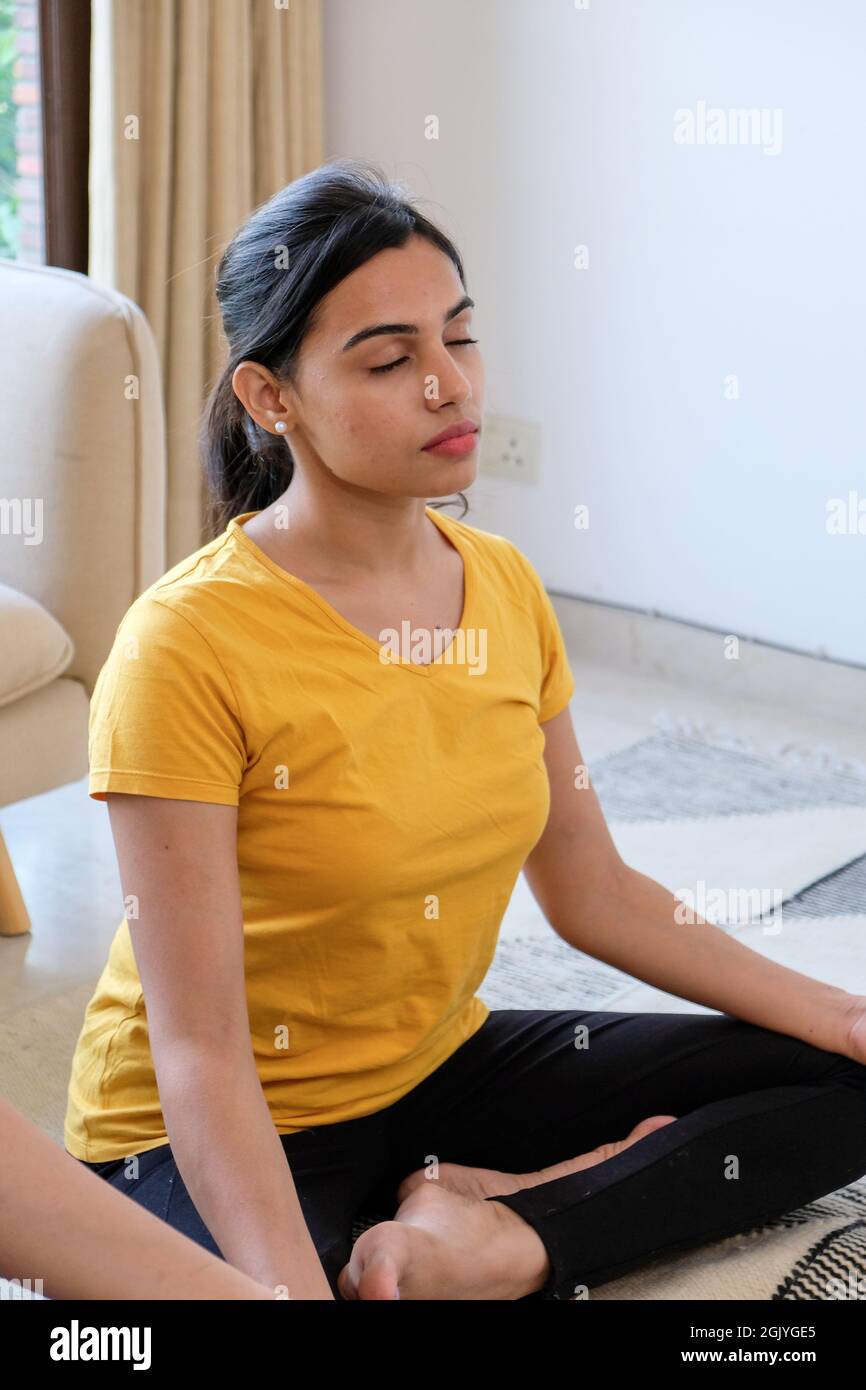 A pretty Indian woman doing stretching at home Stock Photo - Alamy