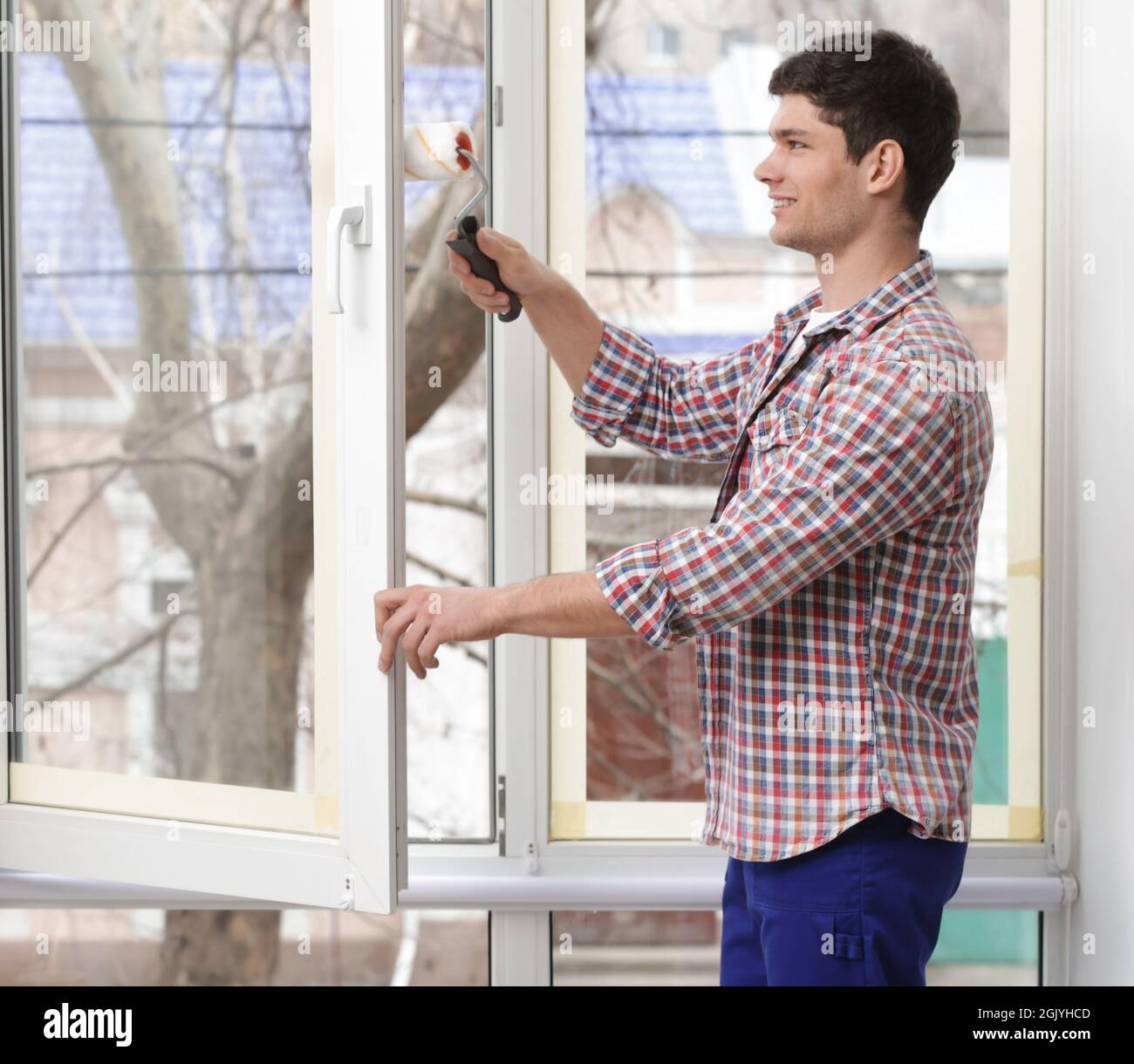 Young man painting window in office Stock Photo - Alamy