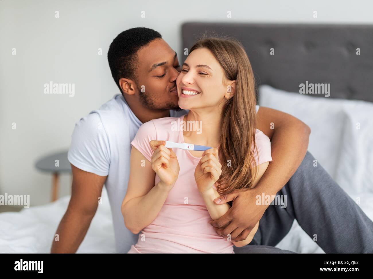 Happy multinational couple celebrating positive result of pregnancy ...