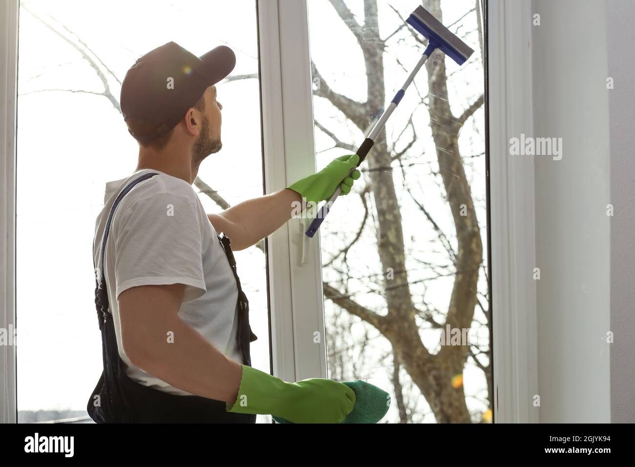 Young man washing window in office Stock Photo - Alamy