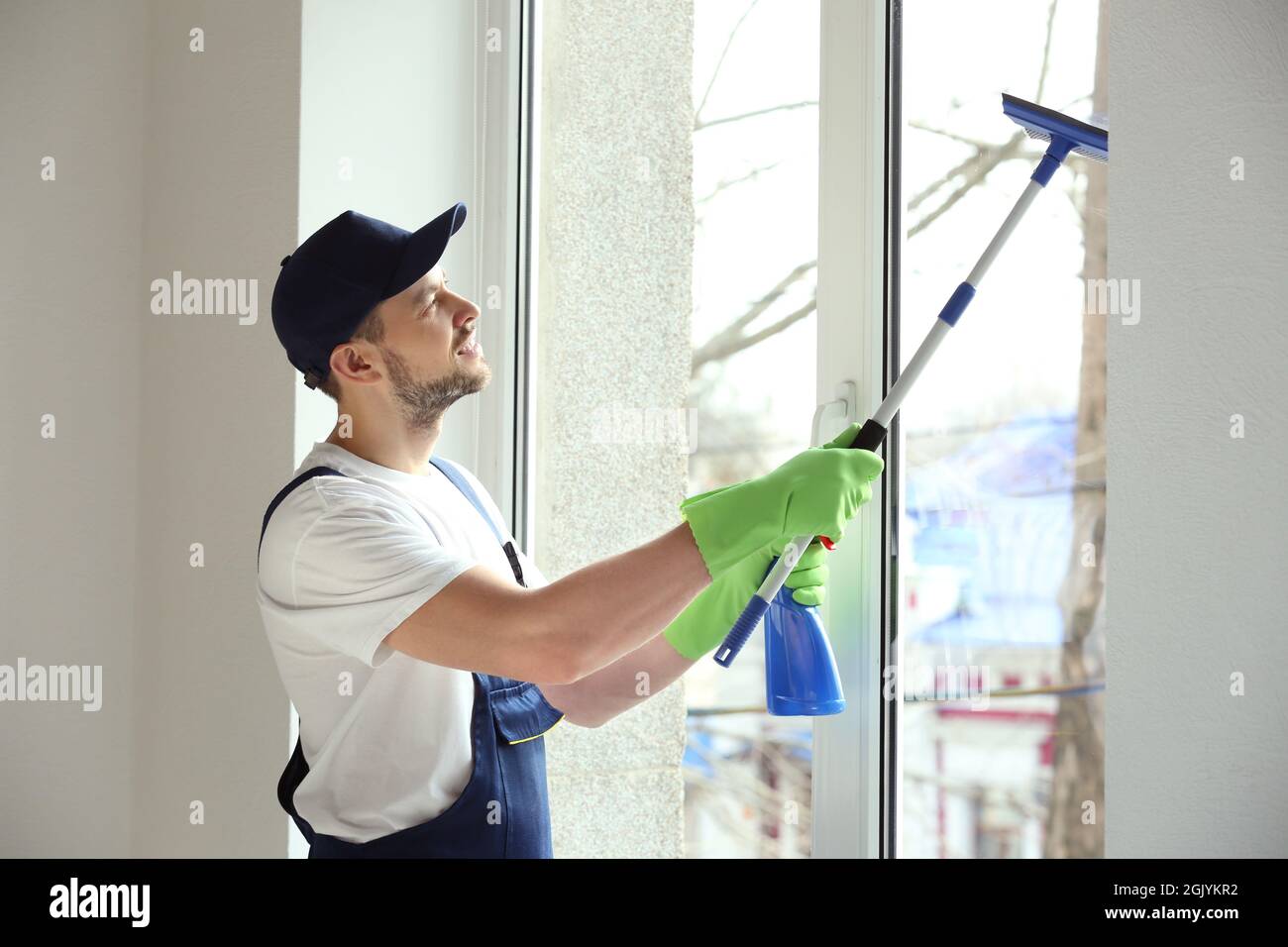 Young man washing window in office Stock Photo - Alamy