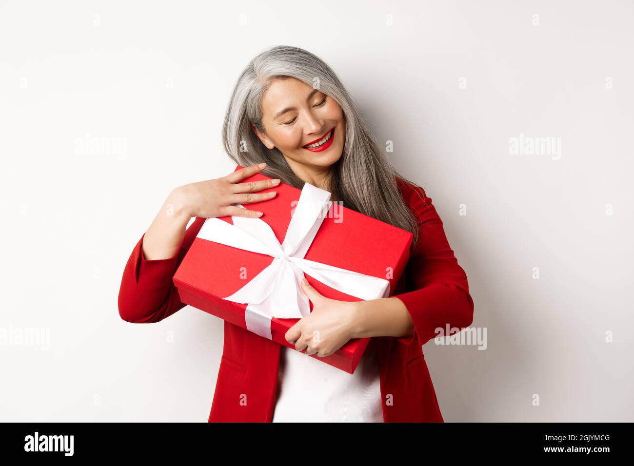Valentine day concept. Beautiful asian senior woman hugging box with ...