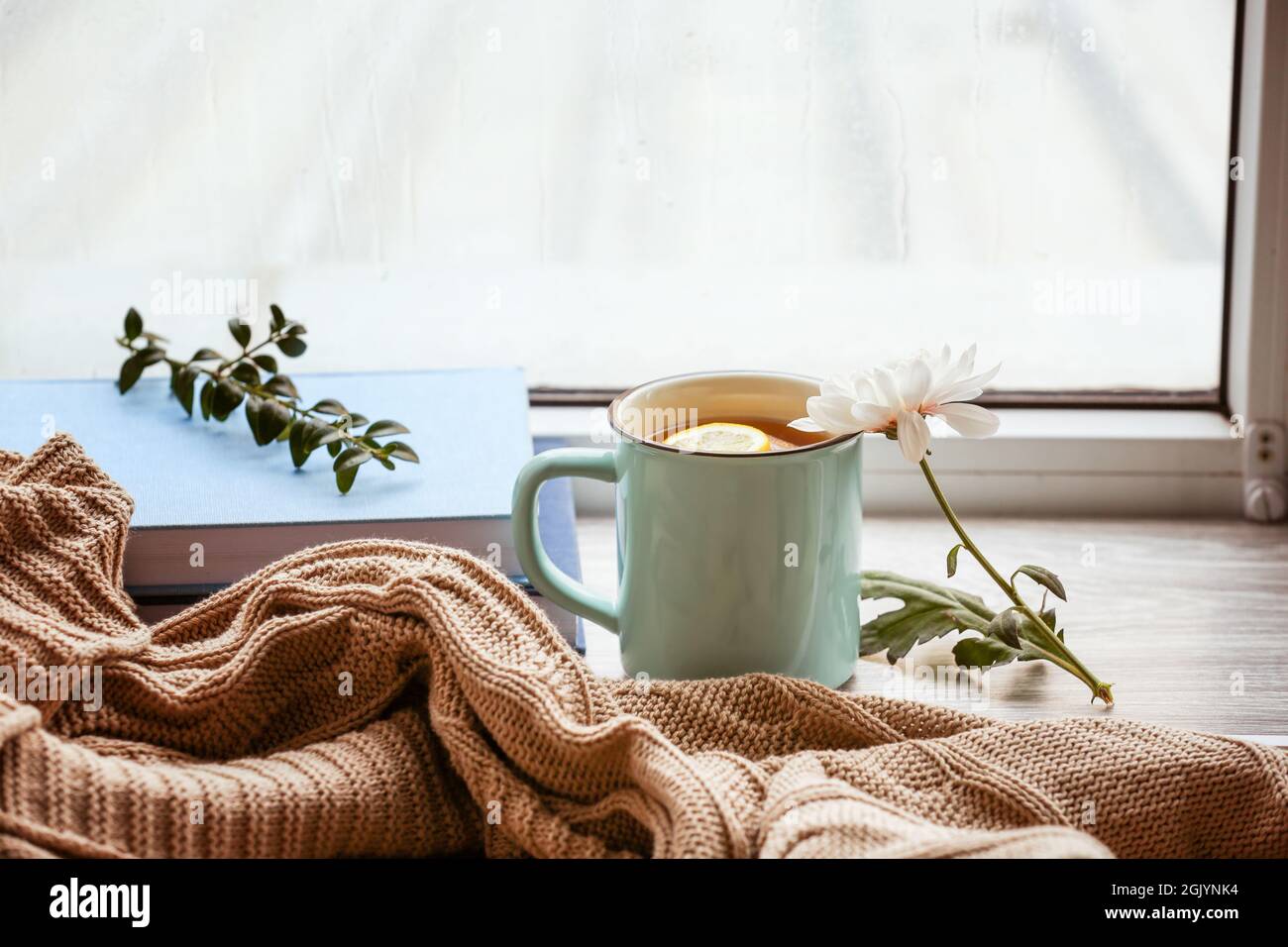 Composition with cup of hot tea on window sill Stock Photo - Alamy