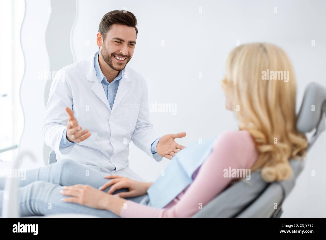 Friendly dentist having conversation with blonde woman patient Stock ...