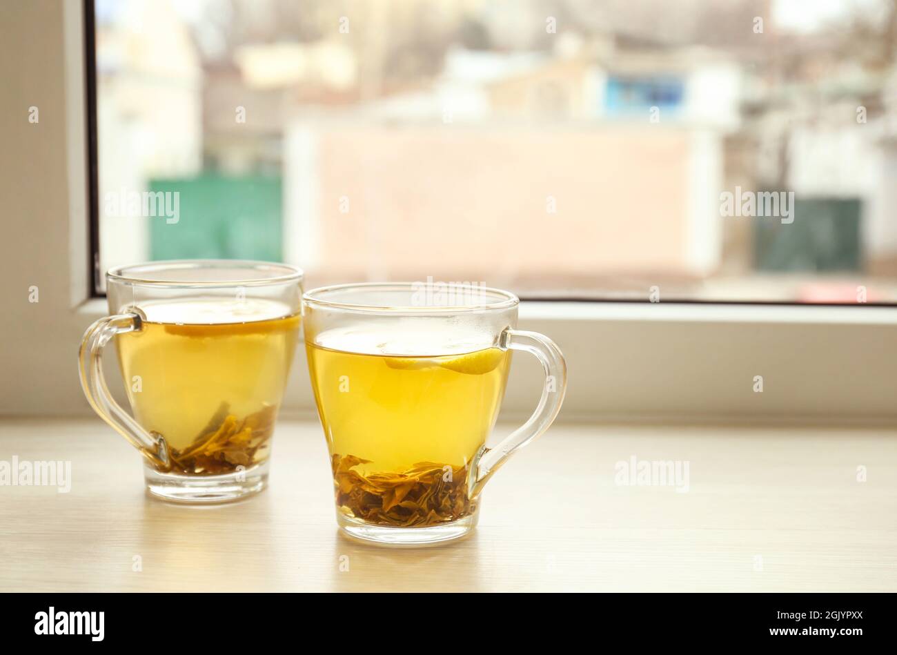 Cups of hot tea on window sill Stock Photo - Alamy