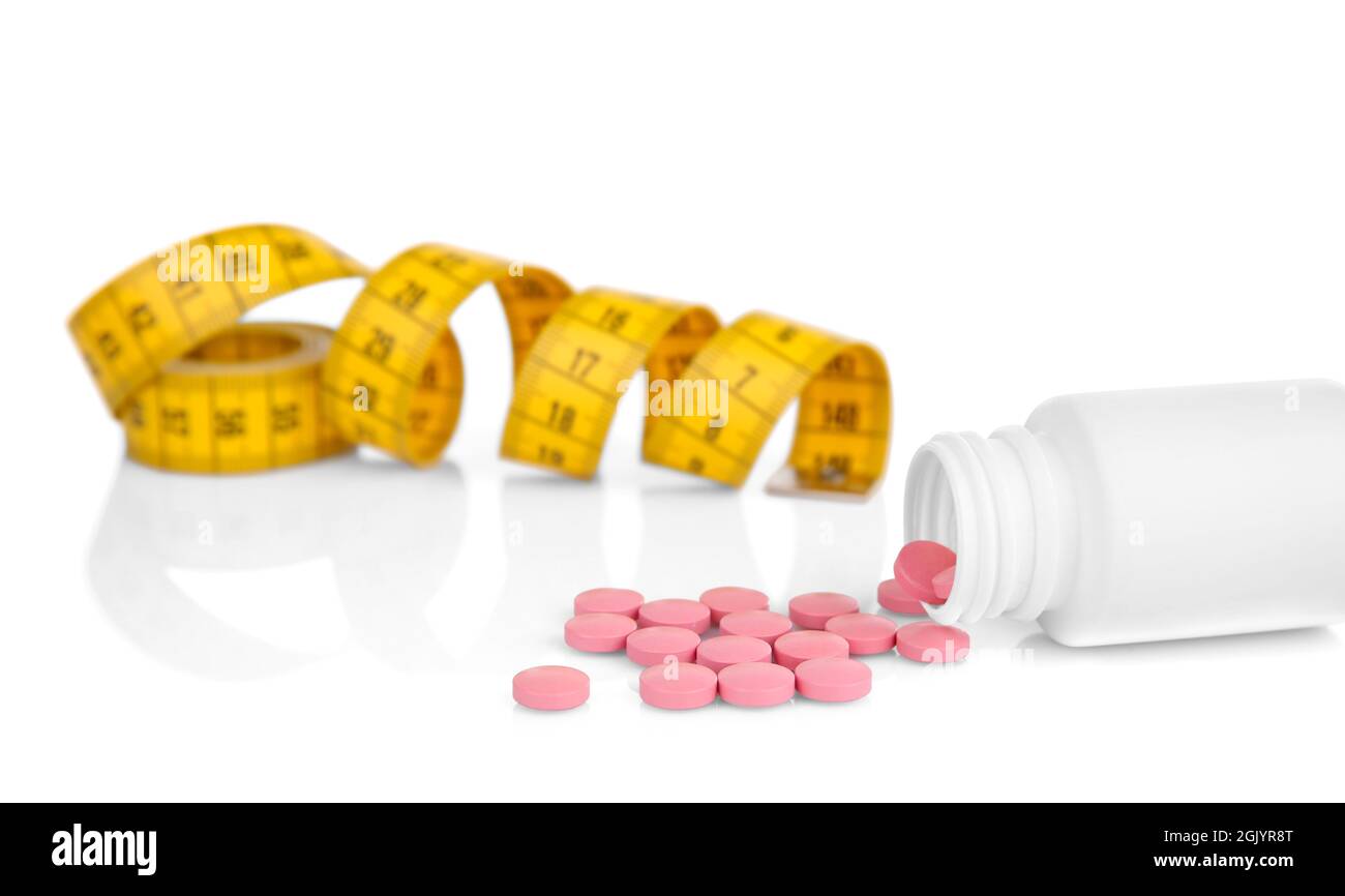 Weight loss concept. Measuring tape and pills on white background Stock ...