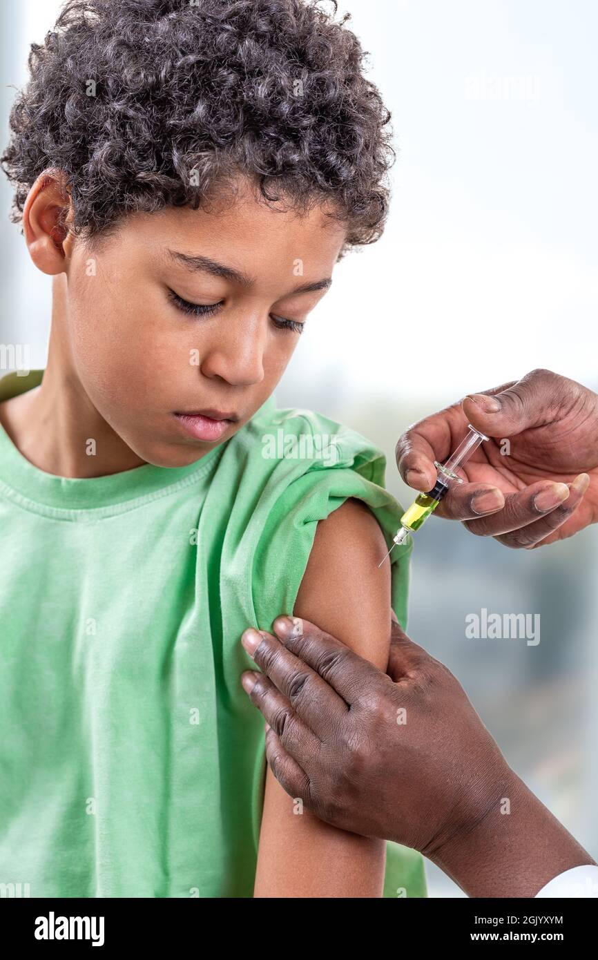 Little boy looking at his arm, while receiving vaccine Stock Photo - Alamy