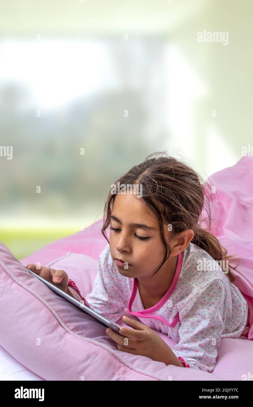 Little girl using digital tablet and playing in bed Stock Photo - Alamy