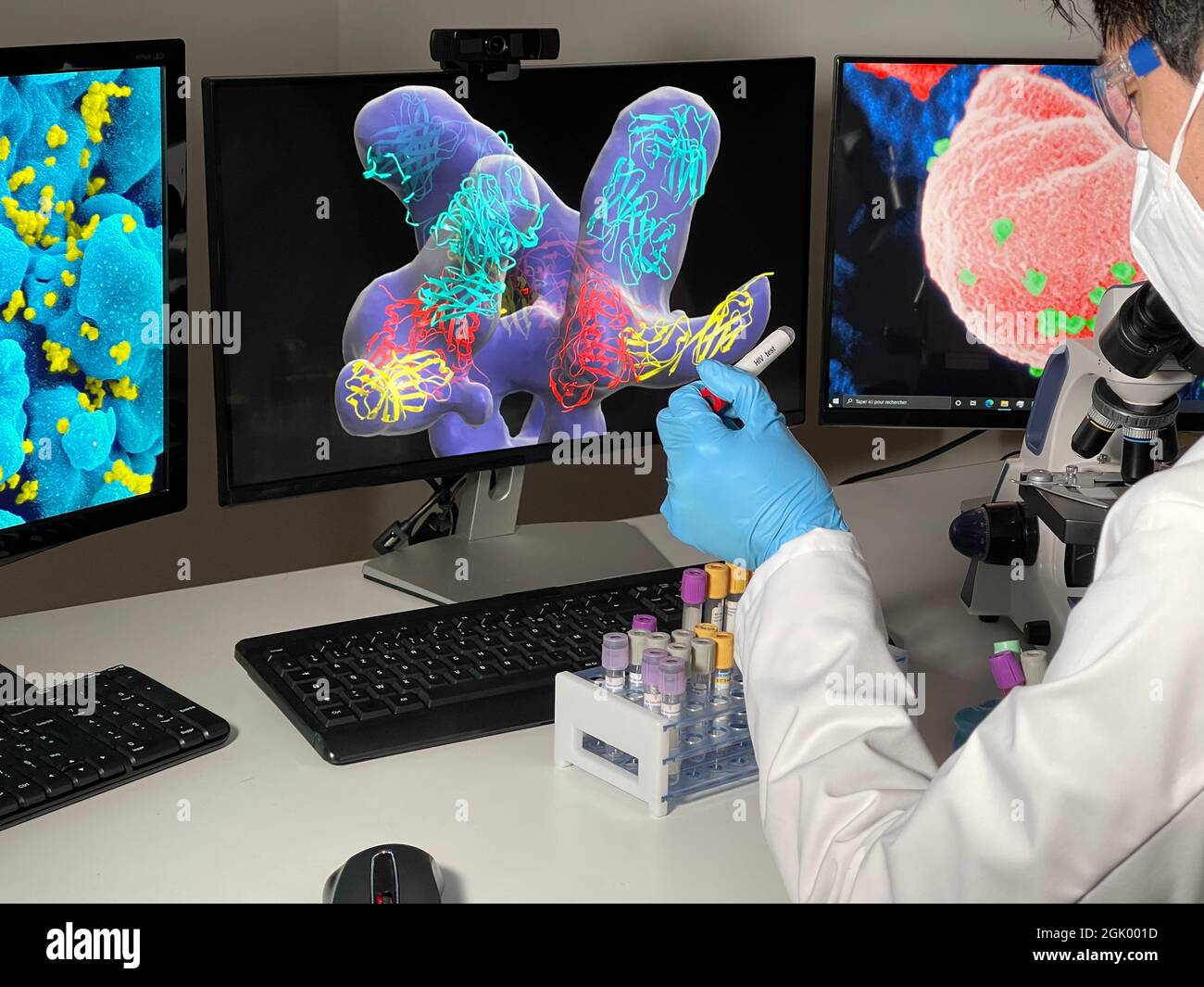 Laboratory technician doing research with images of HIV on a computer ...