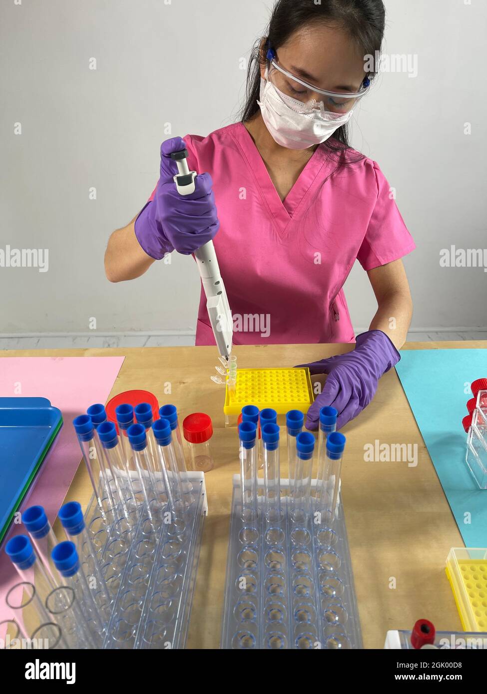 Woman injecting a substance into a tube using a multichannel pipette ...
