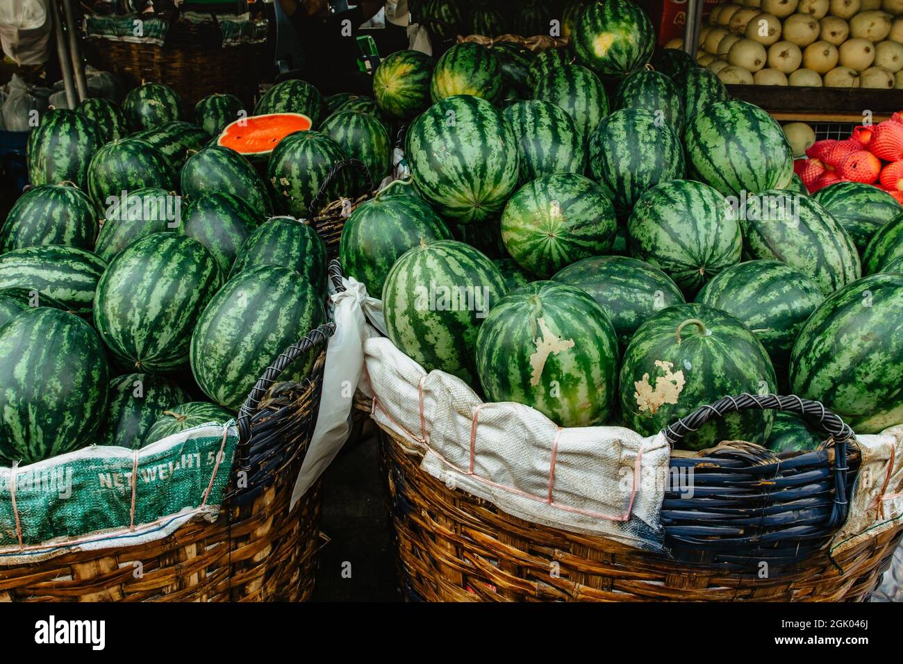 Many big green watermelons in basket and one cut.Sweet juicy summer ...