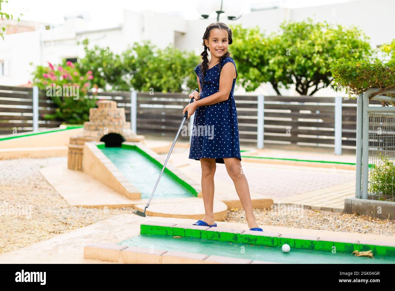 Cute little girl playing mini golf in a park Stock Photo - Alamy