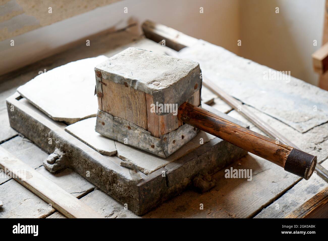 A closeup shot of a wooden hammer with a thick handle and a big square ...