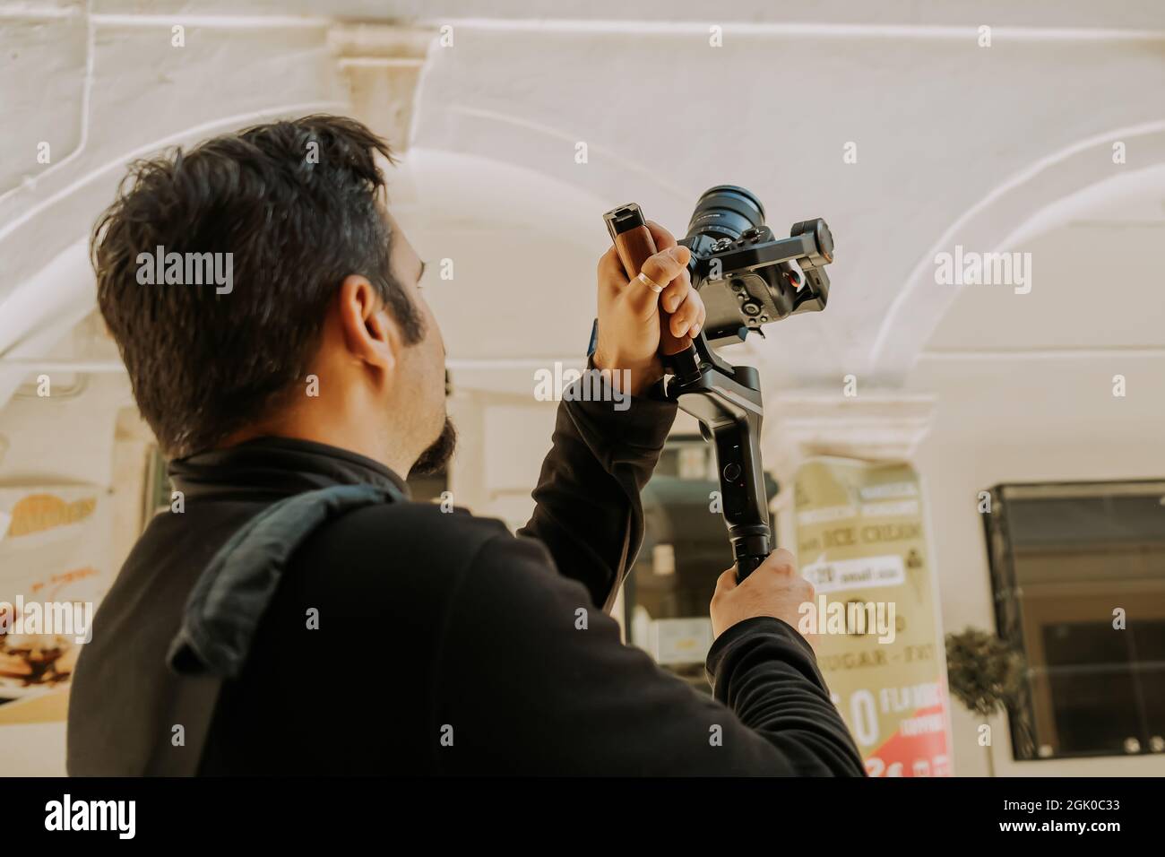 Male cameraman shoots urban architecture and building facades with ...