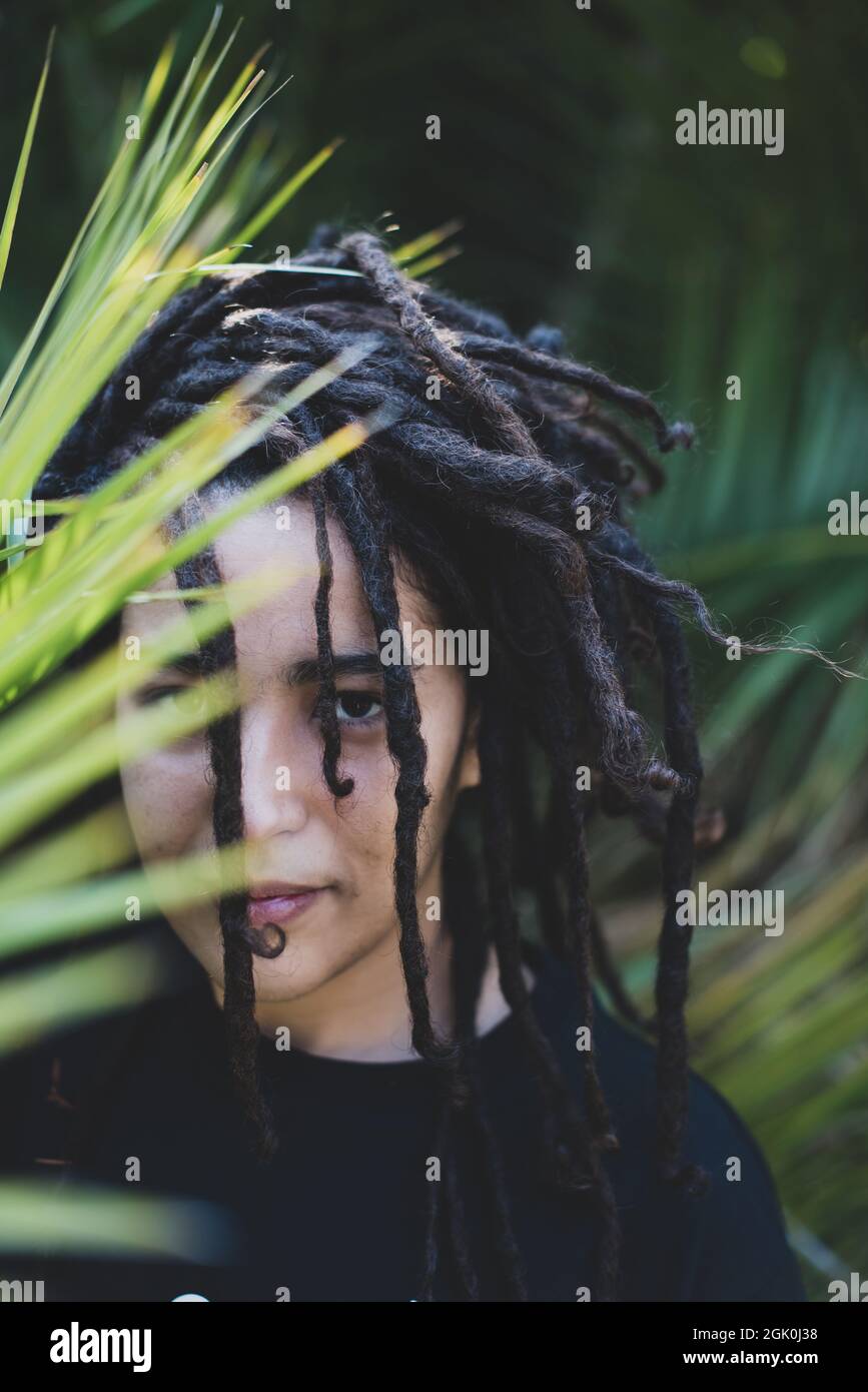 Portrait of woman with locs staring through leaf Stock Photo - Alamy