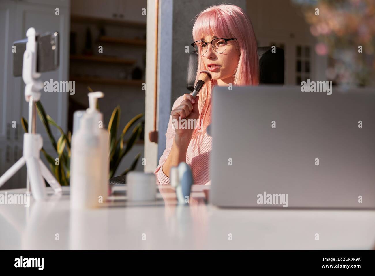 Lady blogger new makeup brush shooting tutorial at table with cosmetic ...