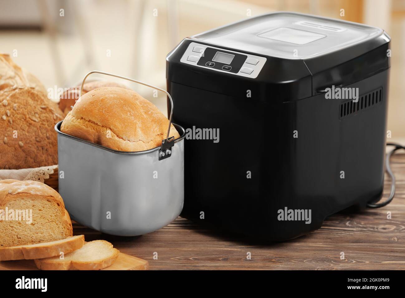 Tasty sliced loaf and bread machine on table Stock Photo - Alamy