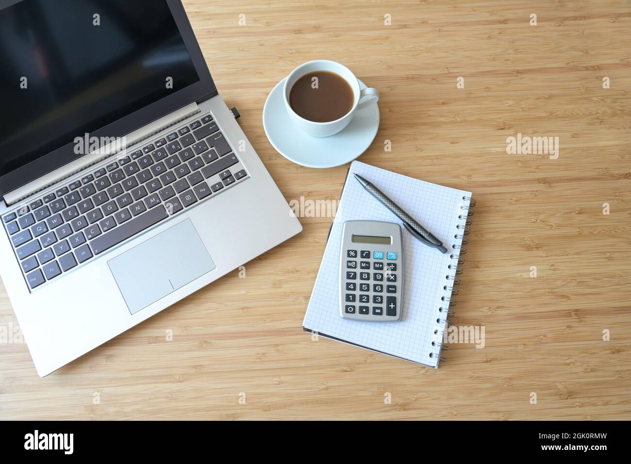 Laptop computer, calculator, spiral book and coffee, flat lay on a ...