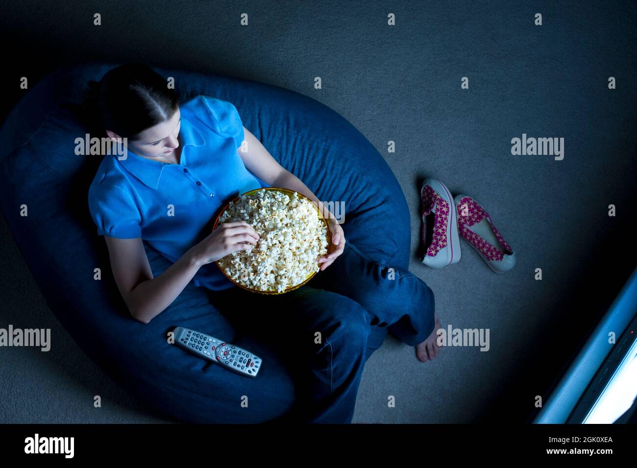 Young teenager watching tv eating popcorn Stock Photo - Alamy