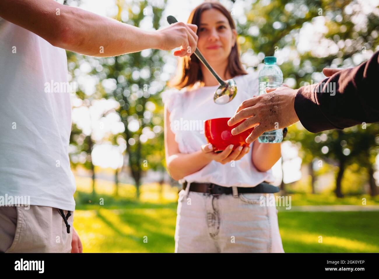 Two young people giving free food for the poor to fill their stomach ...