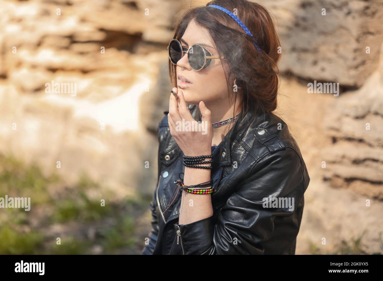 Beautiful young woman smoking weed outdoors Stock Photo - Alamy
