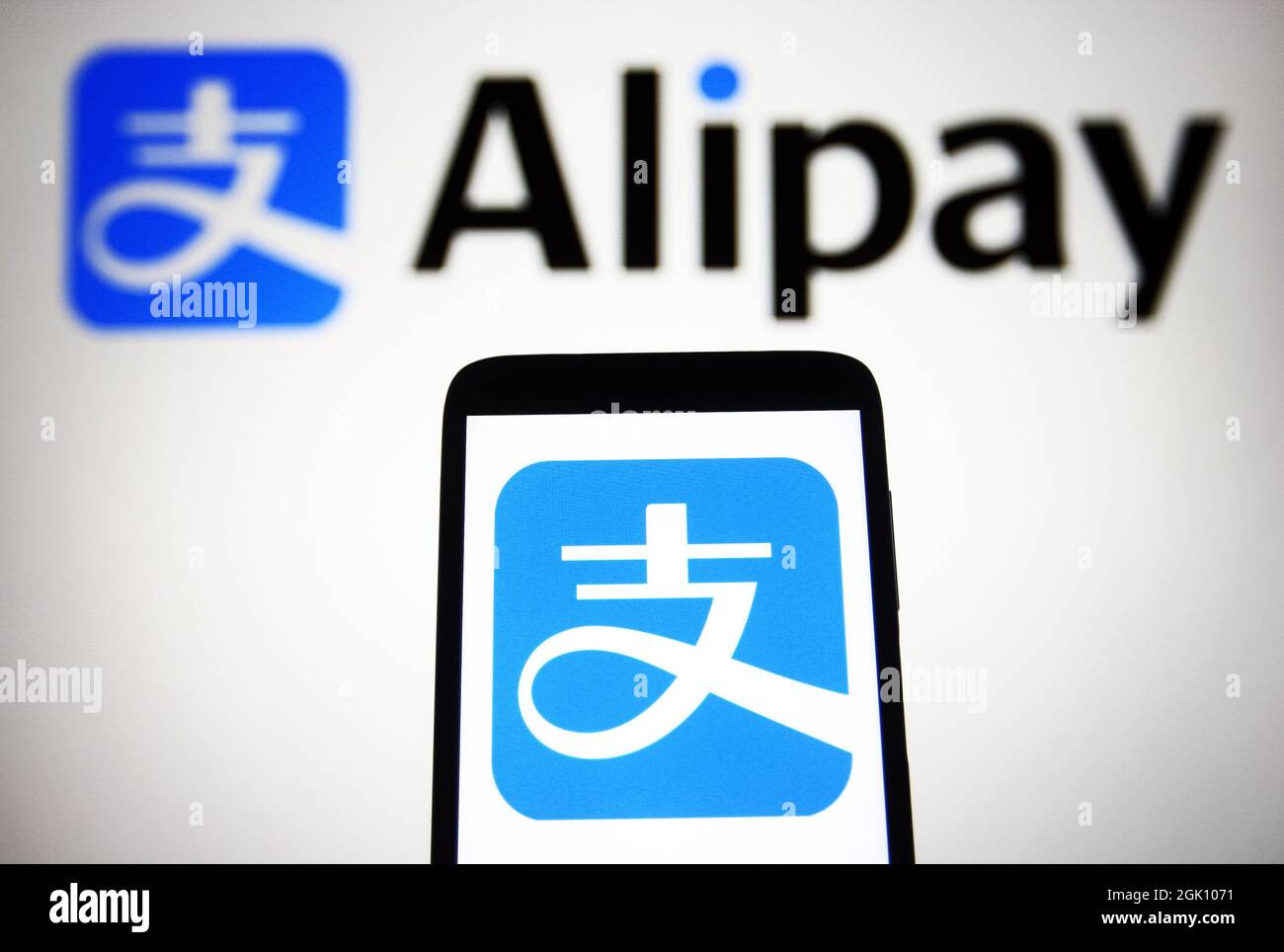 In this photo illustration, Alipay logo is seen on a smartphone and a ...