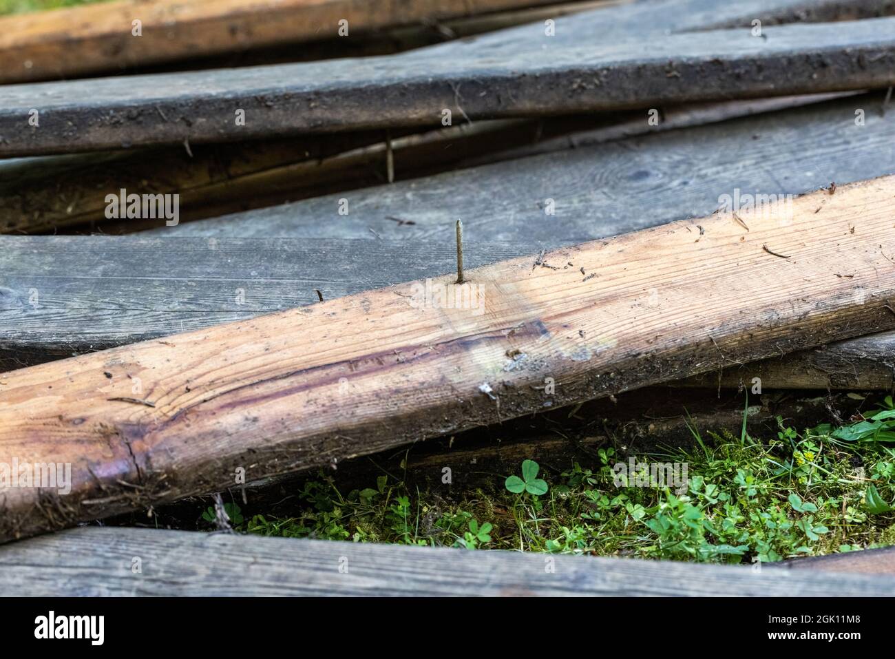 old boards from a torn down structure sitting on green lawn Stock Photo ...
