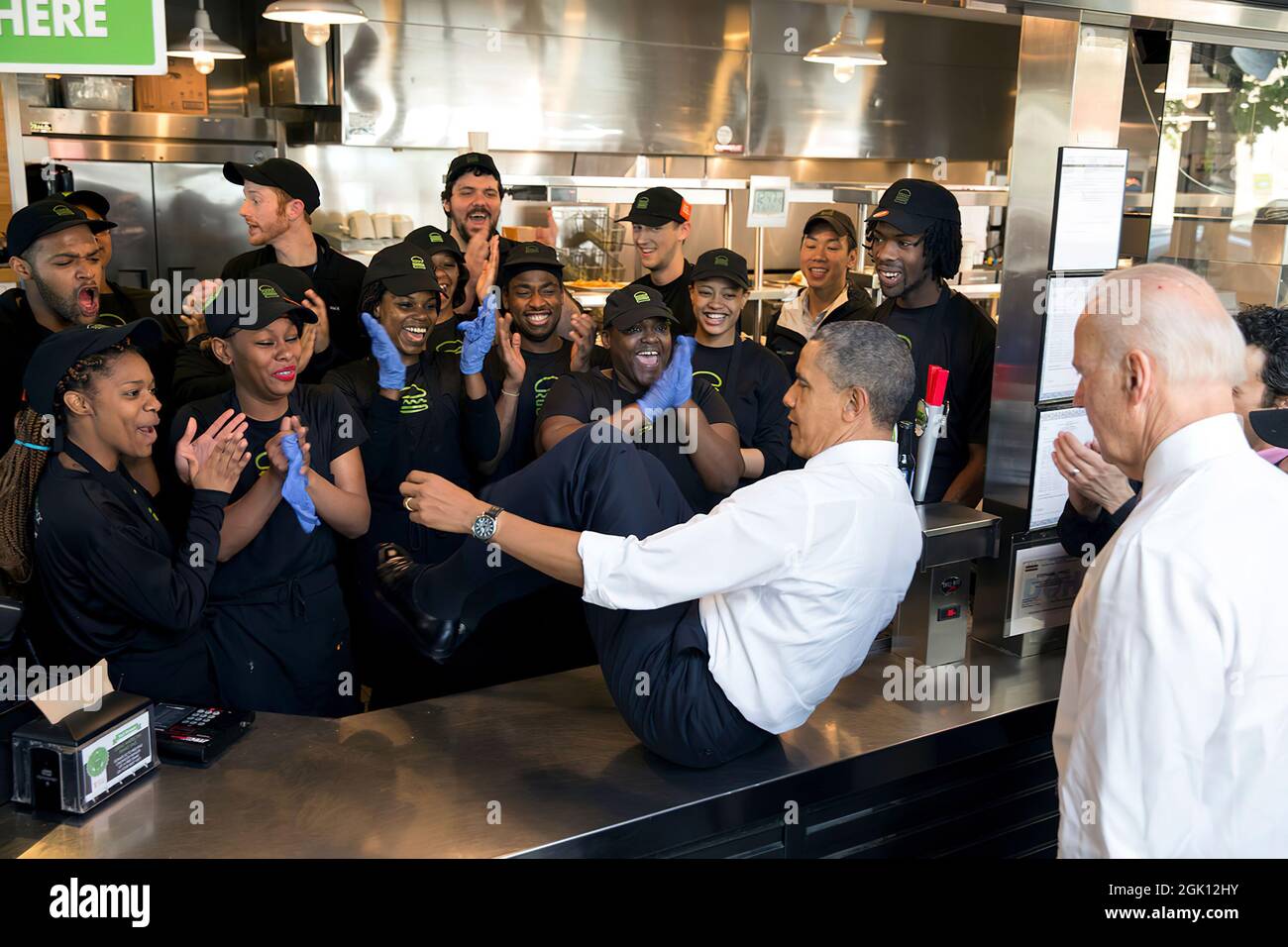 President Barack Obama, with Vice President Joe Biden, slides across a ...