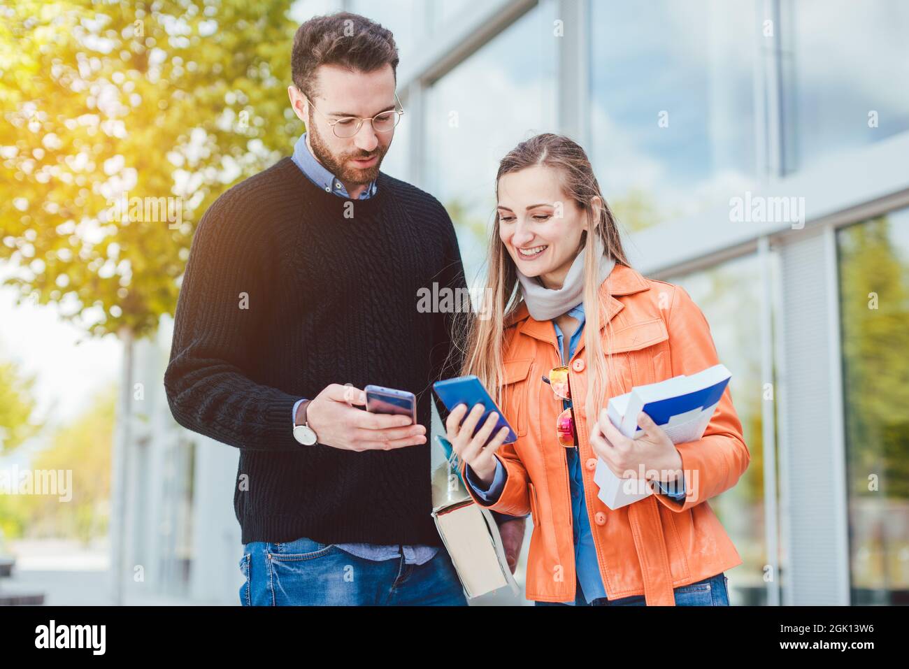 Two students with books on college or university campus Stock Photo - Alamy