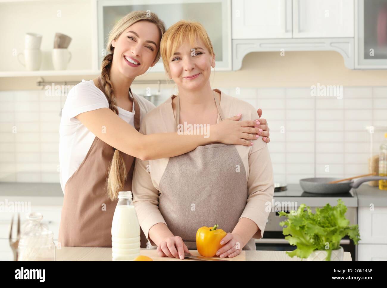 Young woman and her mother cooking in kitchen Stock Photo - Alamy