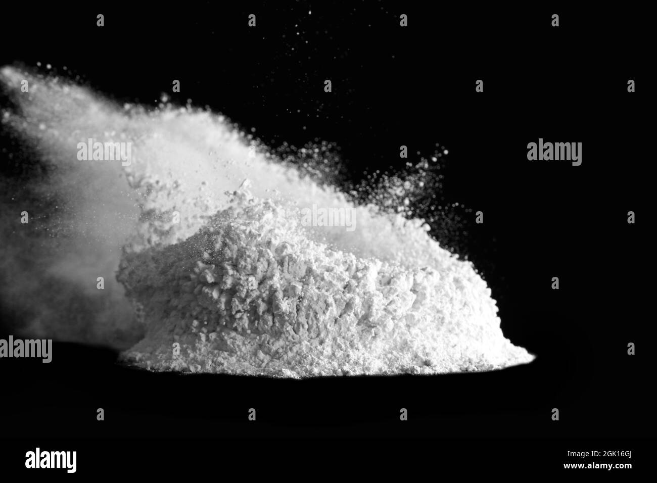 Pile of bursting flour on dark background Stock Photo - Alamy