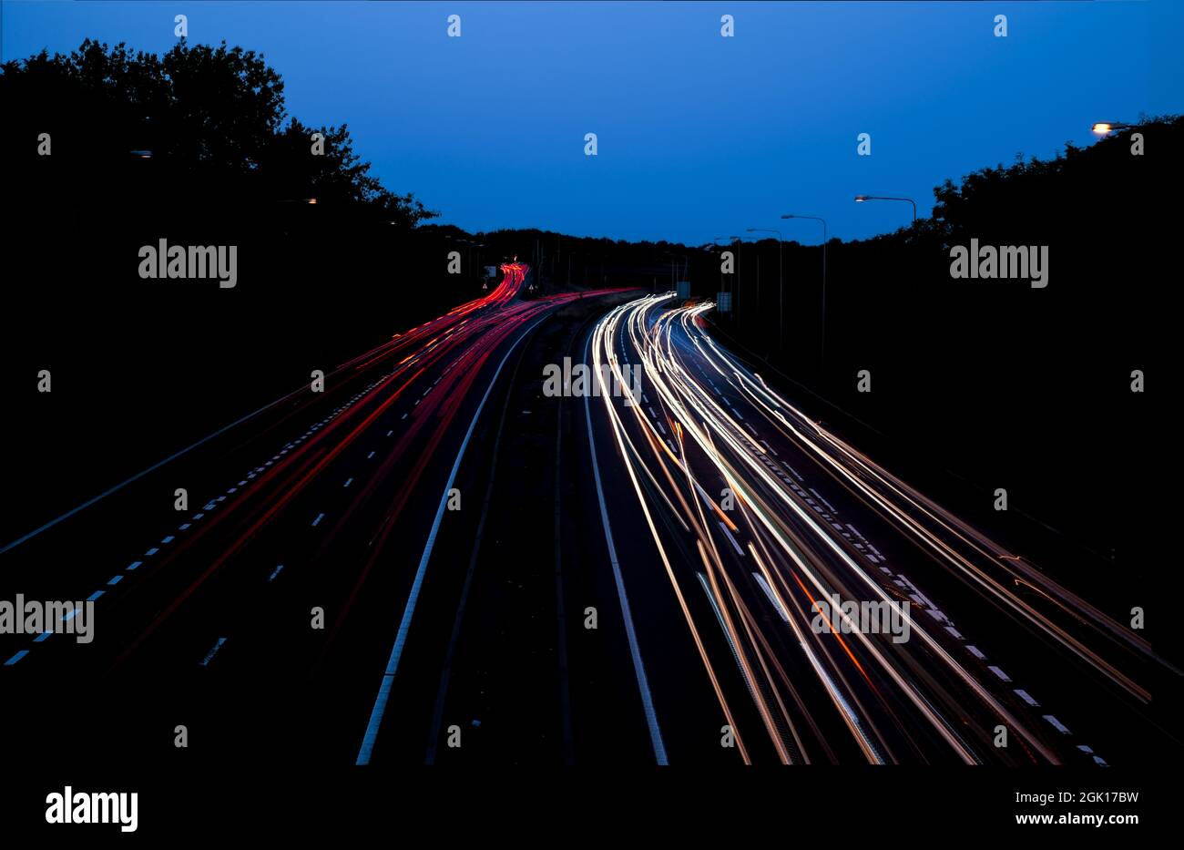 Busy road at night with light trails left by moving cars Stock Photo ...