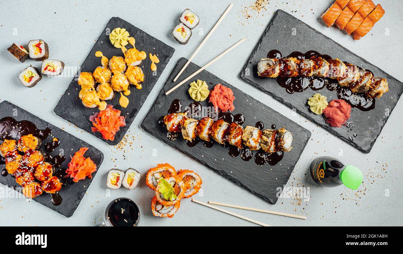 A top view of several plates of colorful sushi rolls arranged like ...